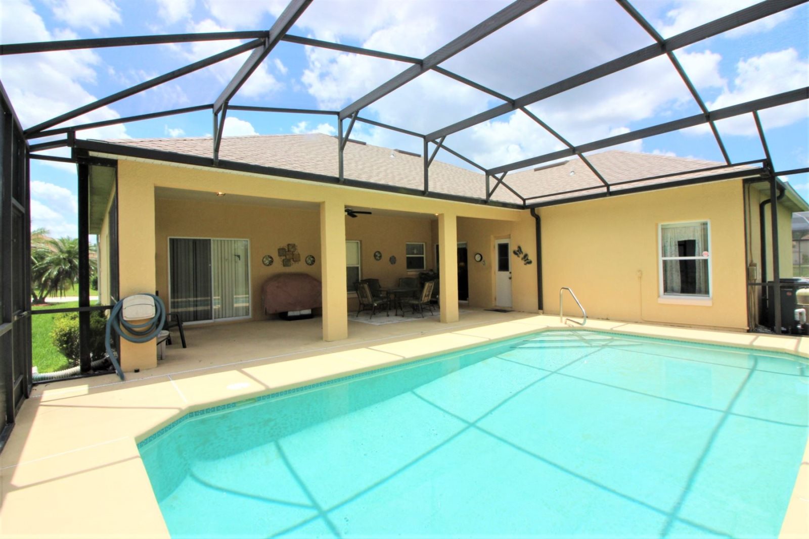 The pool area with covered lanai, lots of seating and BBQ